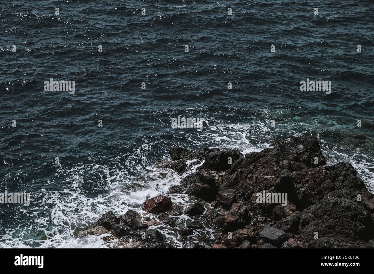 Stone beach of the sea. Top view of the waves and rocks. Close-up ...