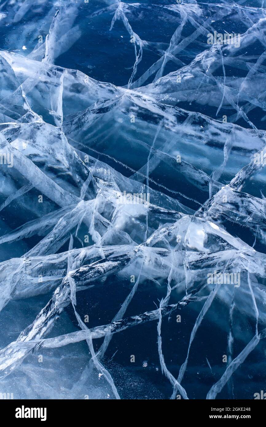 Natural thick clear ice with deep cracks. Blue transparent ice with ...