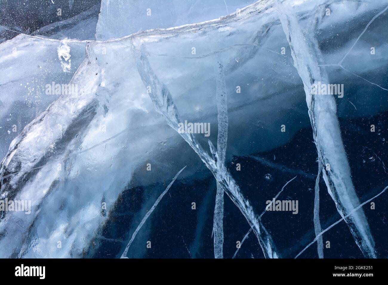 Deep crack in the thick ice of the lake. The natural texture of ice ...