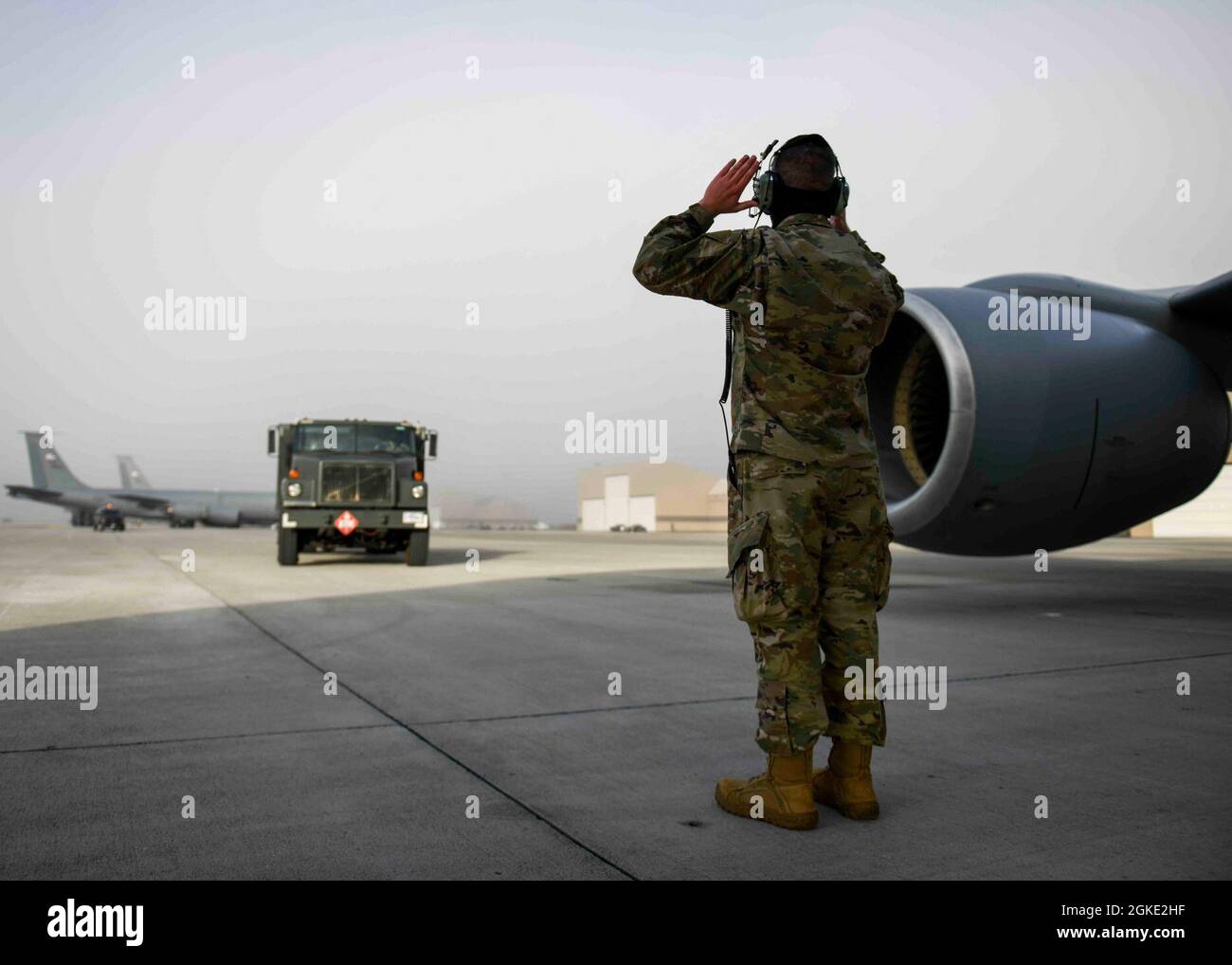 A 92nd Maintenance Squadron Airman guides a fuels truck toward a KC-135 ...