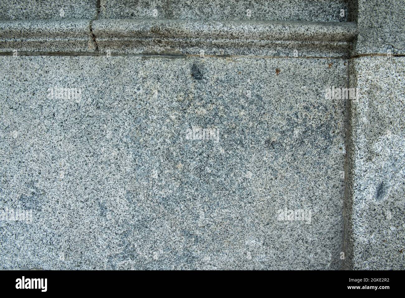 View of gray granite stone texture on a wall of a building with molding ...
