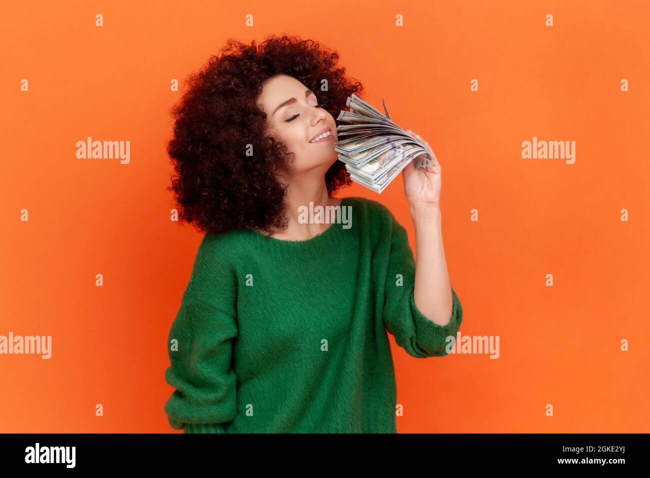 Portrait of greedy woman with Afro hairstyle wearing green casual style ...