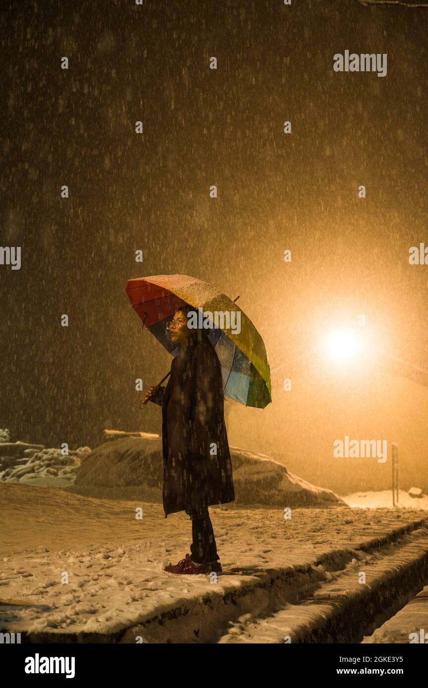 MANALI, INDIA - Jan 23, 2020: A young female with a colorful umbrella ...
