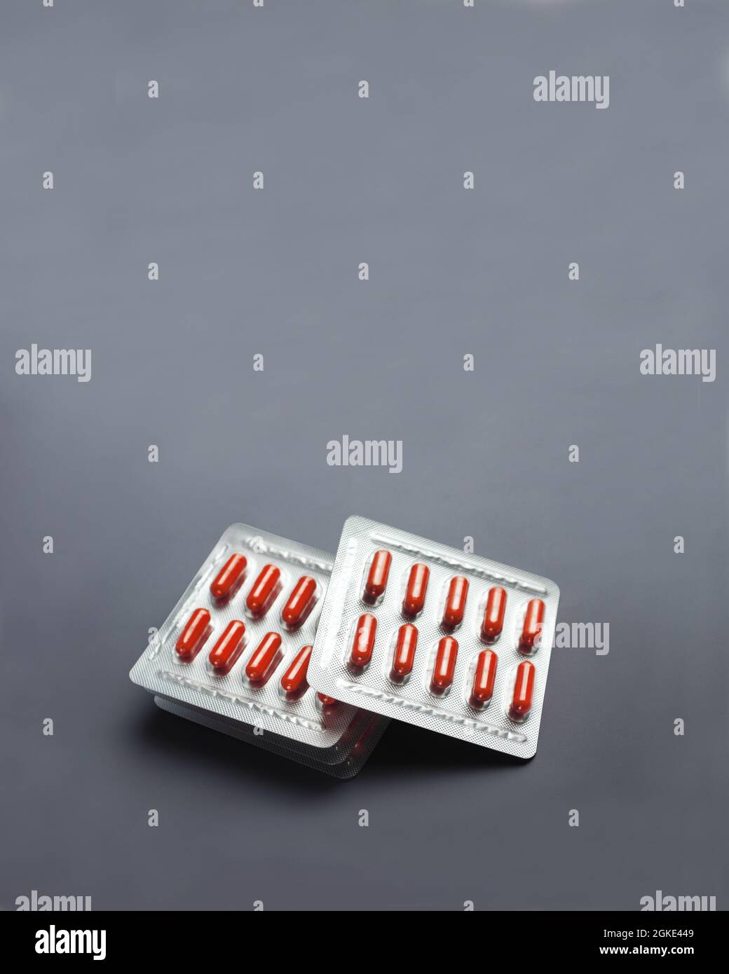 Red pill capsules in blister packs on gray background with clipping ...