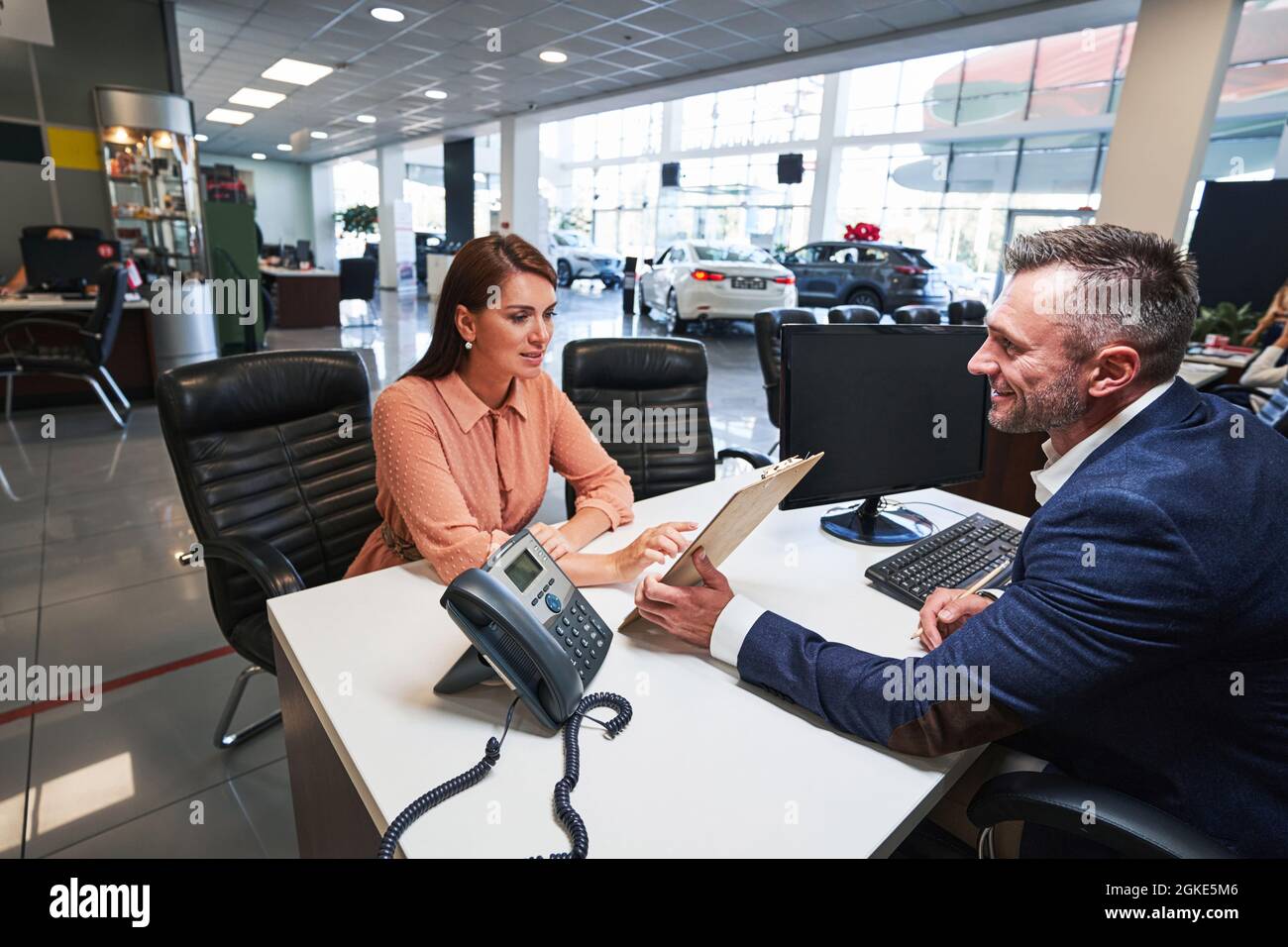 Attentive female customer studying the details in contract Stock Photo ...
