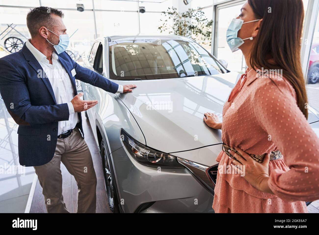 Sales specialist demonstrating the car to his interested customer Stock ...