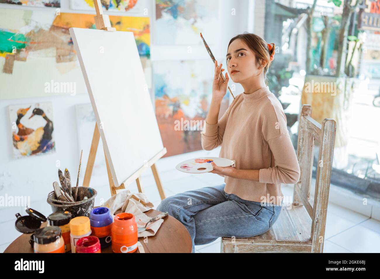 beautiful painter thinking about what to paint while sitting in her ...