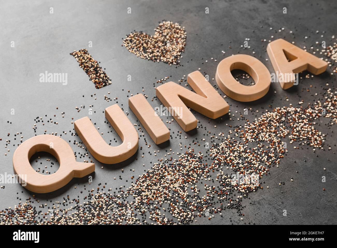 Text I LOVE QUINOA made with wooden letters and seeds on table Stock ...
