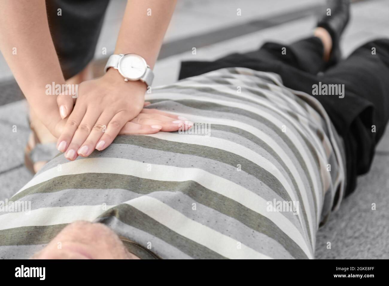Woman giving first aid to man with heart attack outdoors Stock Photo ...