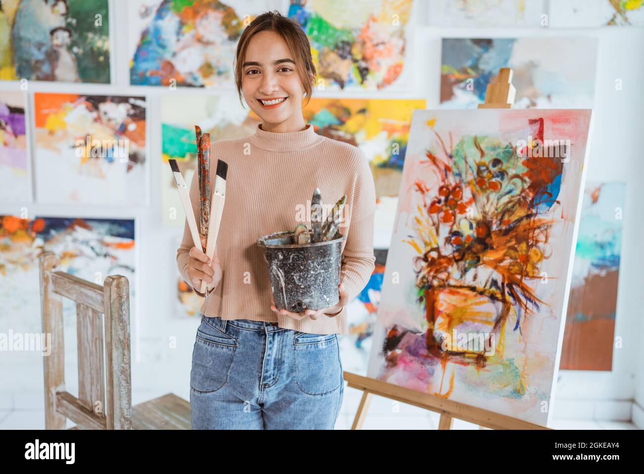 female artist standing and smile in front of her work Stock Photo - Alamy