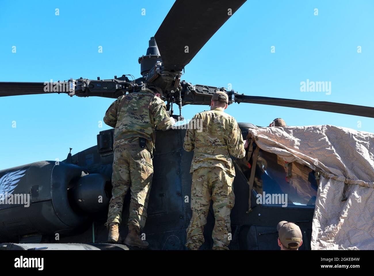 U.S. Army soldiers preform post-flight procedures on an AH-64D Apache ...