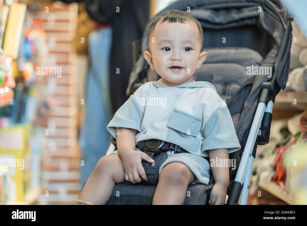 cute baby boy sitting on a stroller in the shopping mall Stock Photo ...