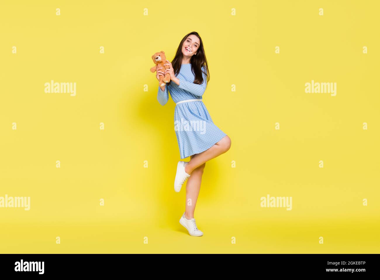 Photo of charming lady stand tiptoe hold fluffy soft bear toy wear ...