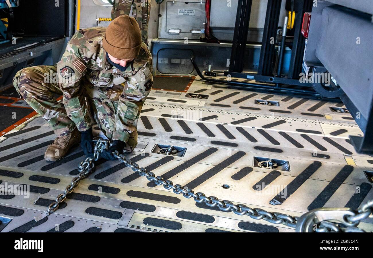 Staff Sgt. Jared Soucy, 3rd Airlift Squadron loadmaster, ties a ...