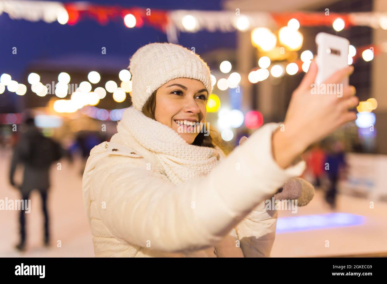 Christmas, winter, technology and leisure concept - happy young woman ...