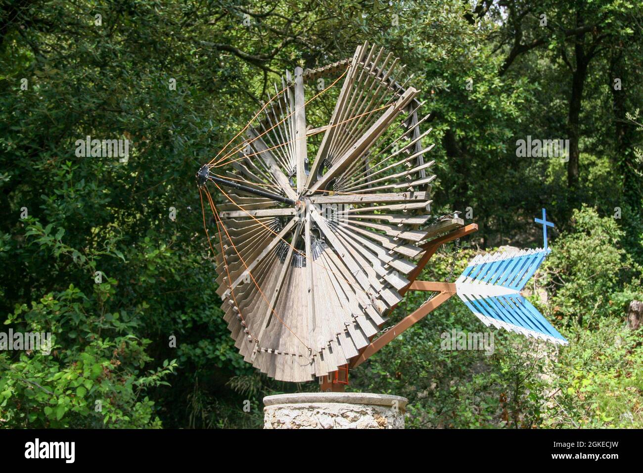 Wooden decoration looking like a wheel attached to a stone pillar ...
