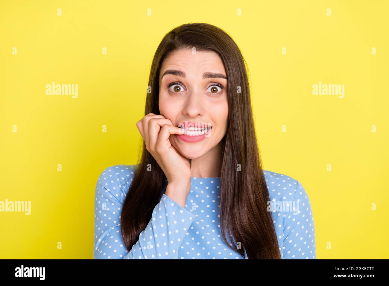 Photo of charming scared young woman dressed blue clothes biting ...