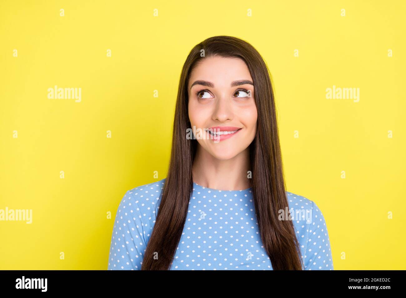 Photo Of Curious Tempting Girl Bite Lip Look Empty Space Wear Dotted Blue Dress Isolated Yellow