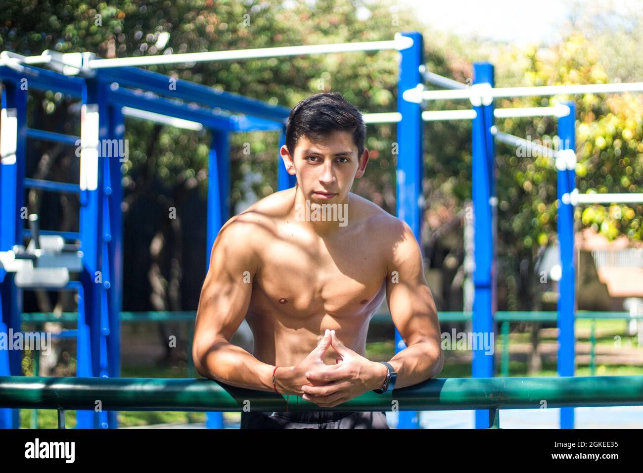 Young, muscular Colombian man taking a rest during workout in a sunny ...