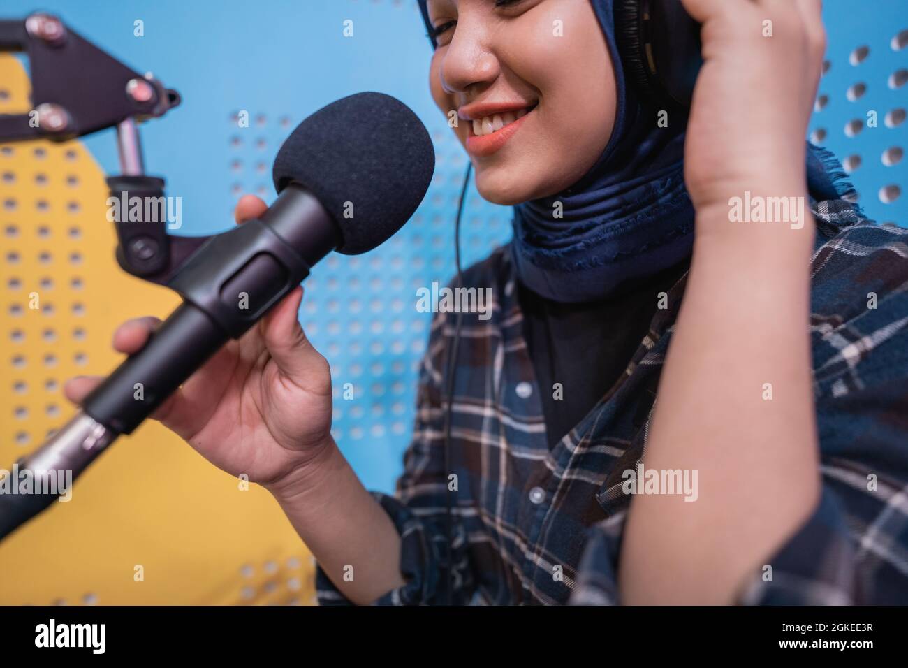 muslim woman girl is recording a podcast in her studio Stock Photo - Alamy