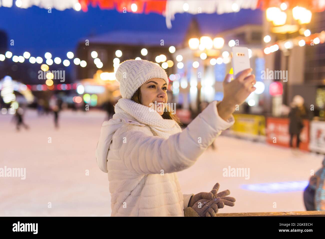 Christmas, winter, technology and leisure concept - happy young woman ...