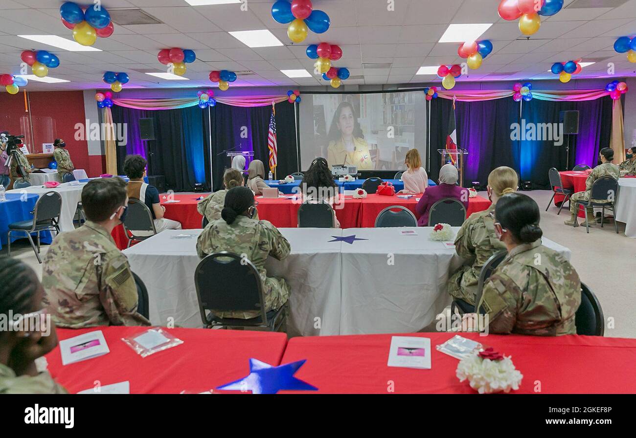 Attendees observe a video of Sheikha Intisar Salem Al Ali Al Sabah, a ...