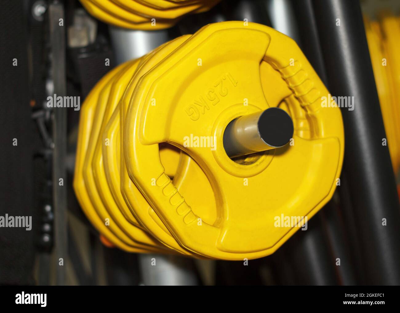 Barbell yellow plates holder rack in the gym Stock Photo - Alamy