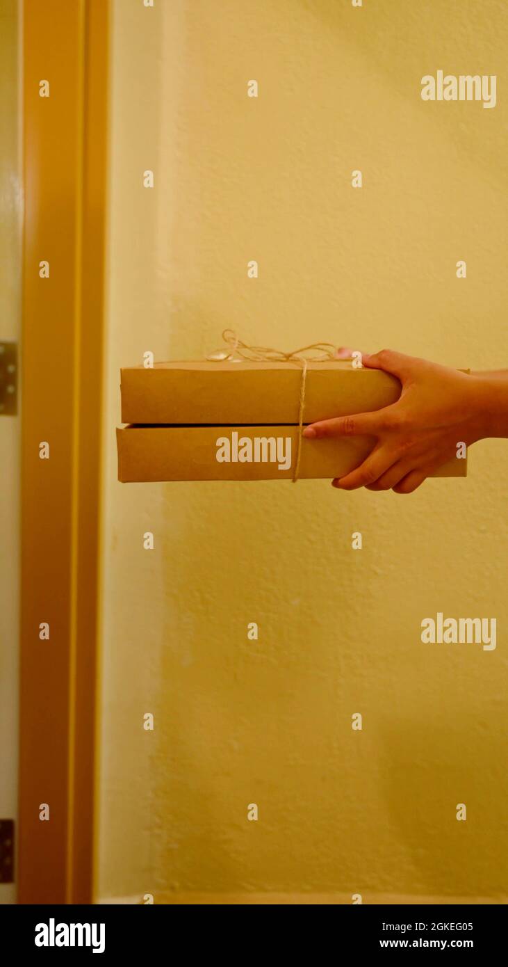 A delivery man is showing packages at the door Stock Photo - Alamy