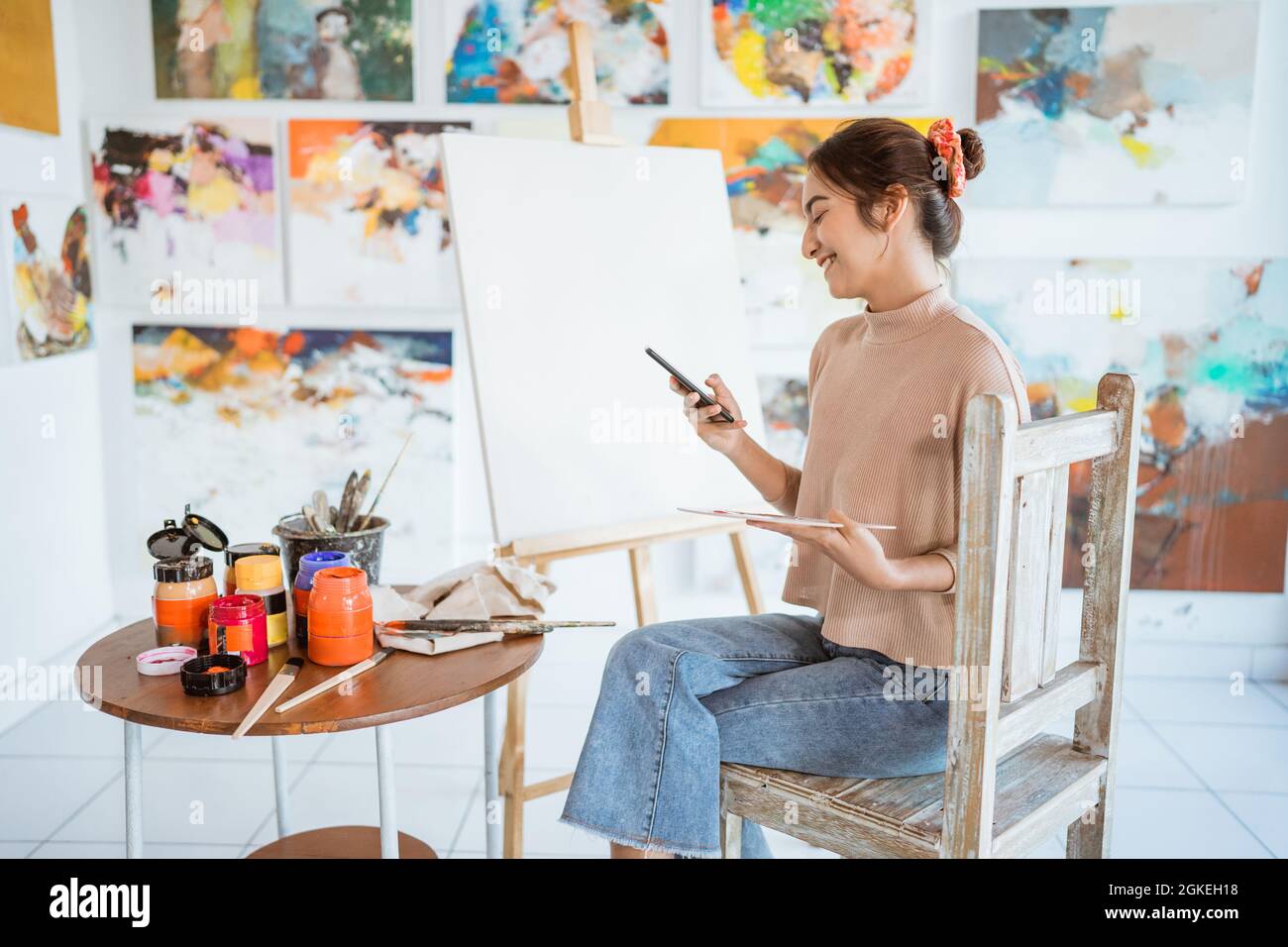 female artist looking for inspiration from her mobile phone Stock Photo ...