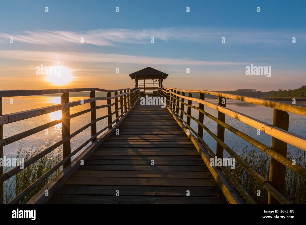 sunset over the lake, wooden pier and a covered observation deck Stock ...