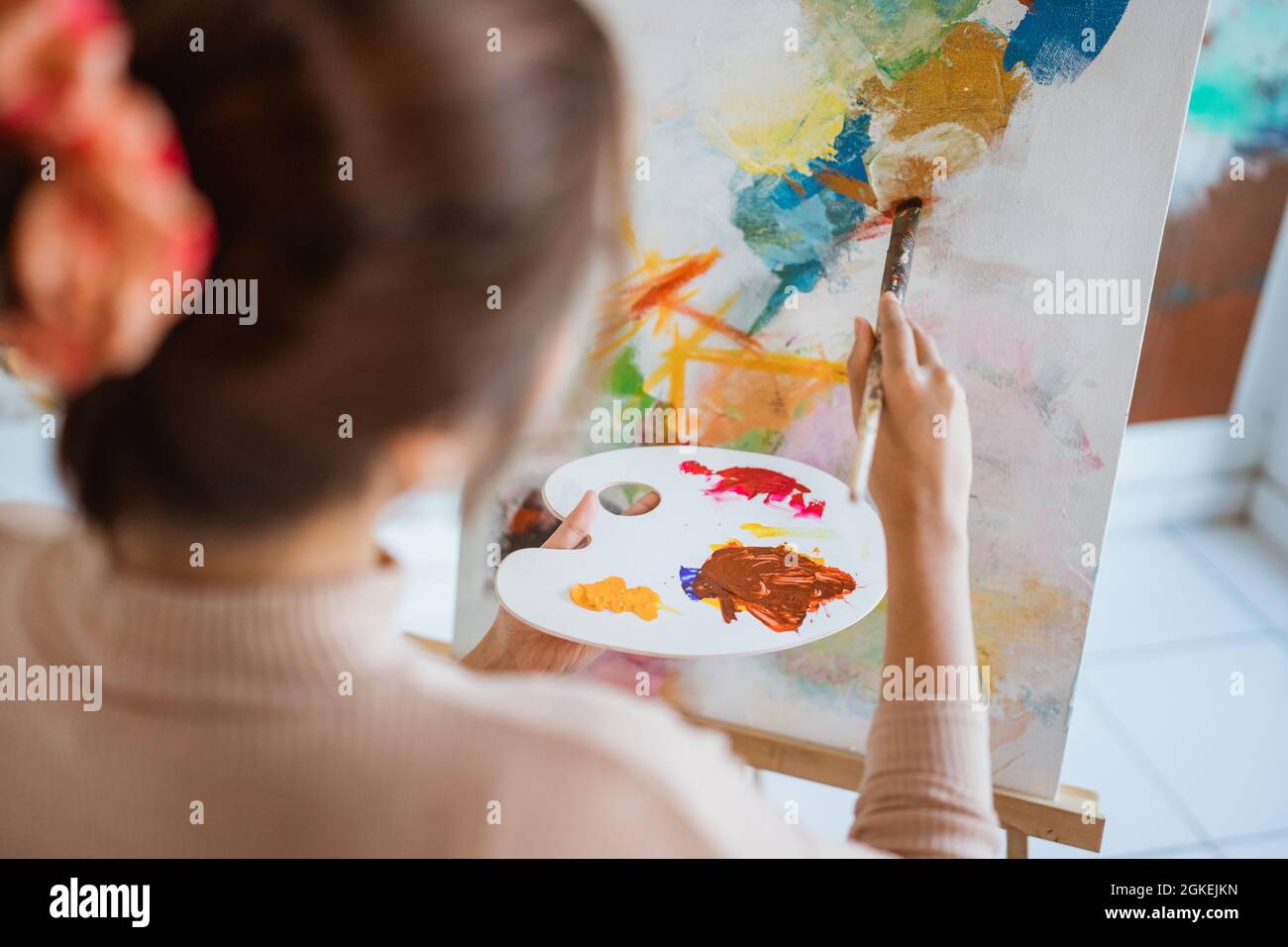 painter artist painting on canvas shoot from her back Stock Photo - Alamy
