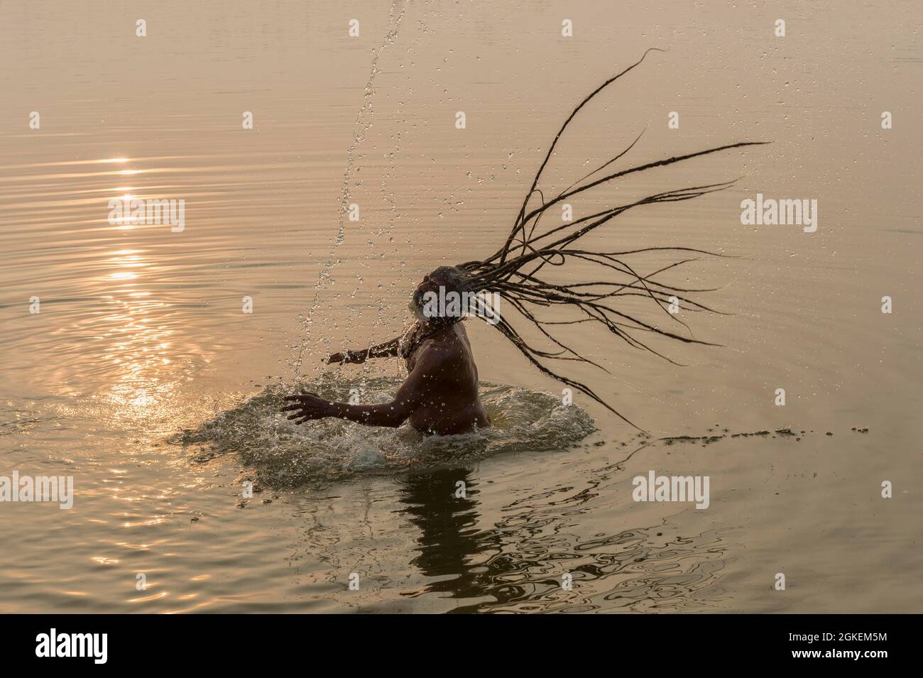 Rom Baba with water spraying from his flying dreadlocks in the river ...