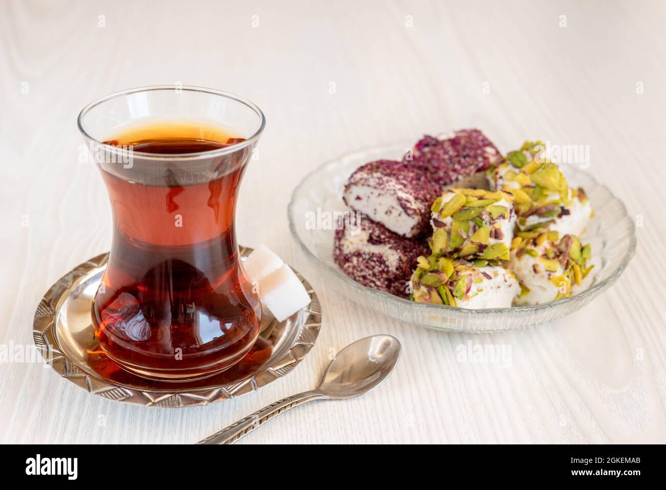Traditional Turkish tea in a glass with sweets and a spoon Stock Photo ...