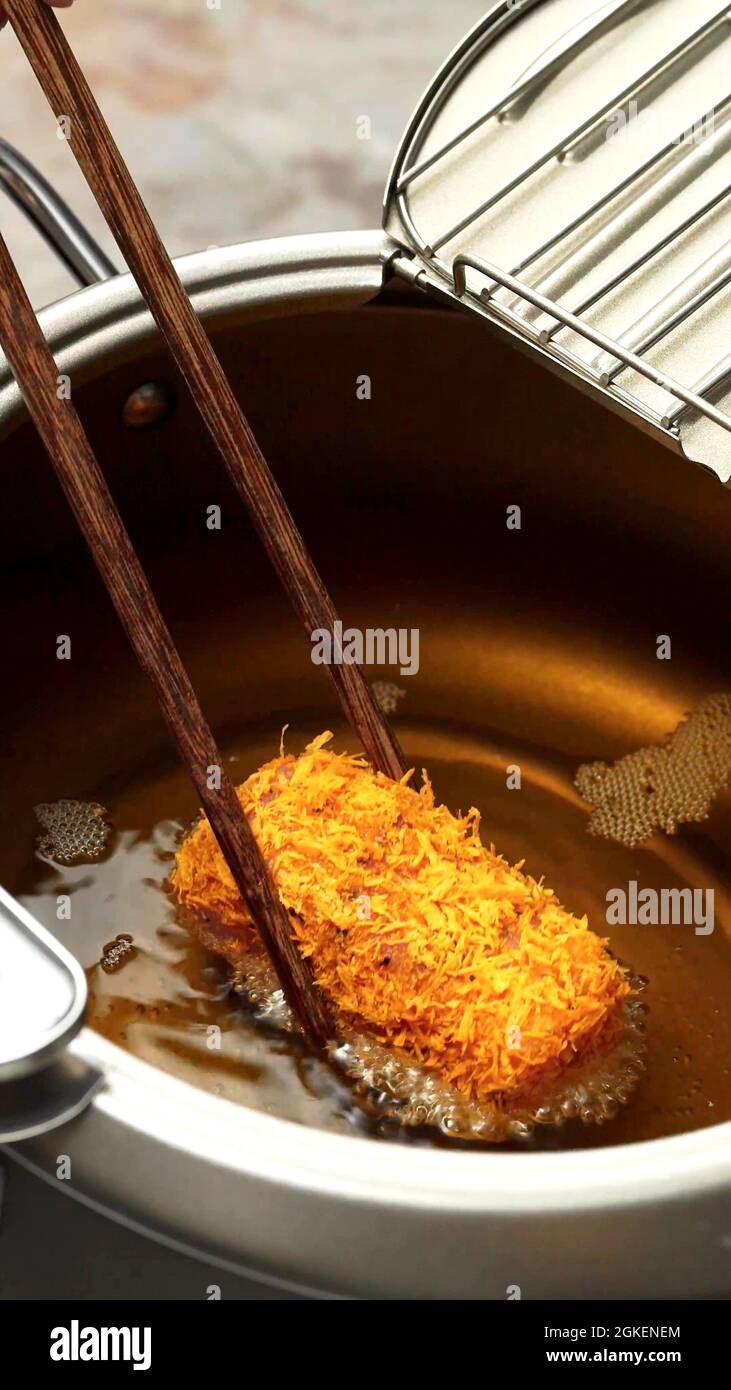 Vertical photo of Asian food cooking in oil Stock Photo - Alamy