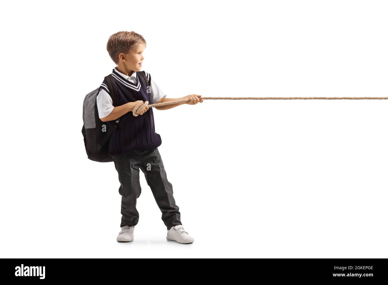 Full length profile shot of a little schoolboy pulling a rope isolated ...