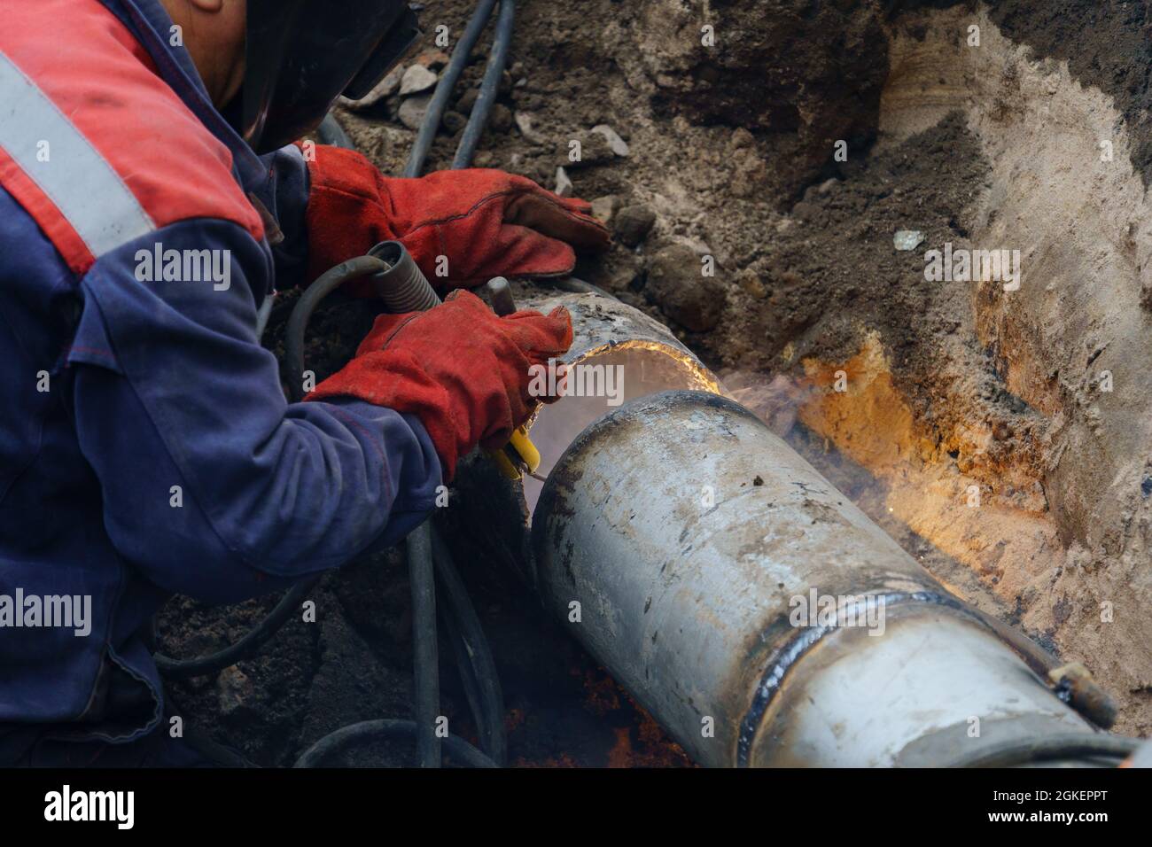 Utility worker fixing broken water main. Sewerage pipe repair concept ...