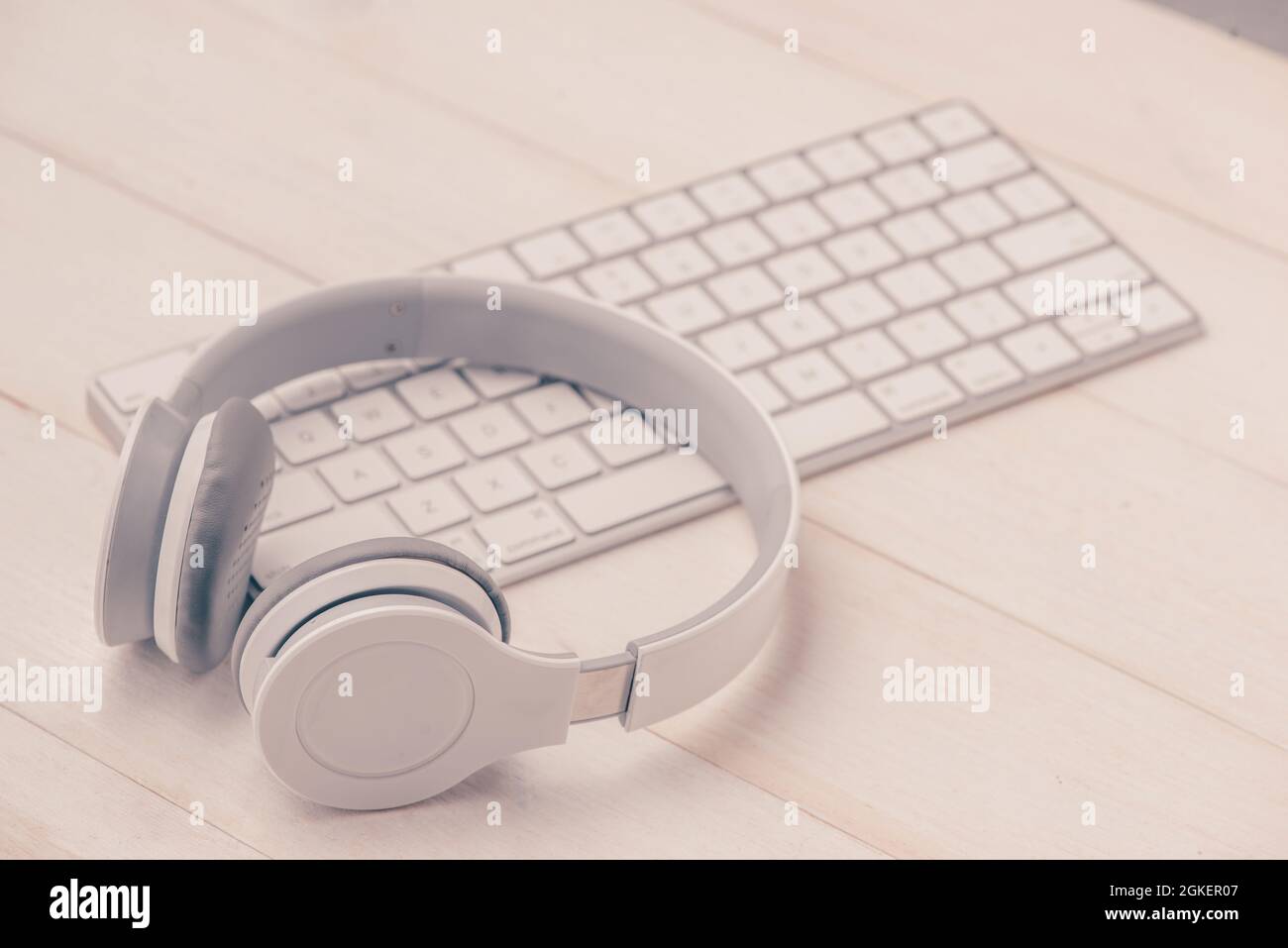 Notepad and computer on white table with headphone. View from above ...