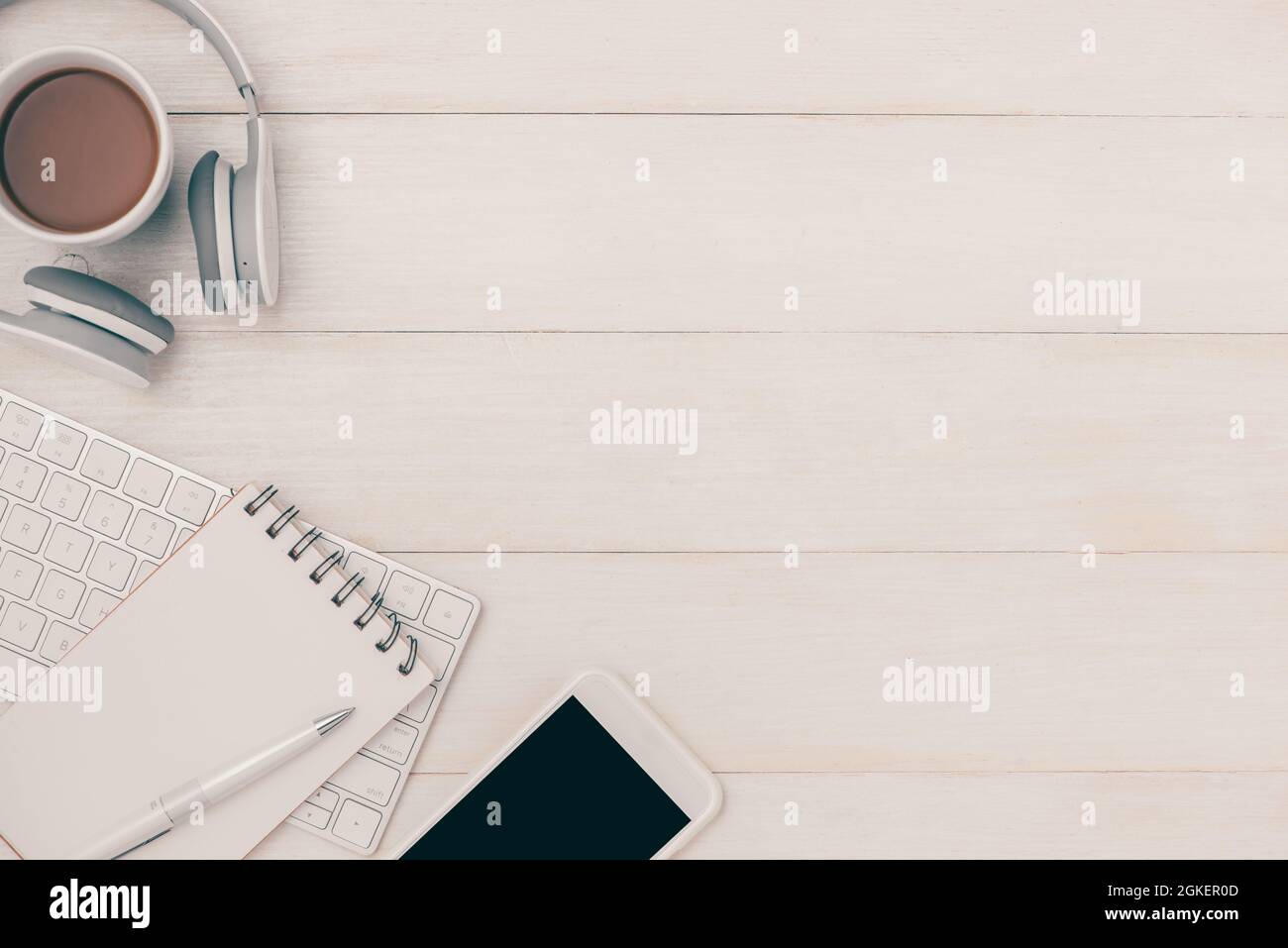 Notepad and computer keyboard on white table with headphone. View from ...