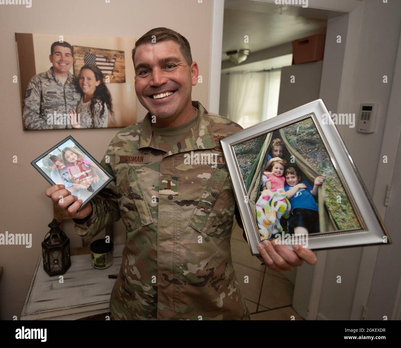 Second Lt. Adam Borgman poses with photos of his family while wearing ...