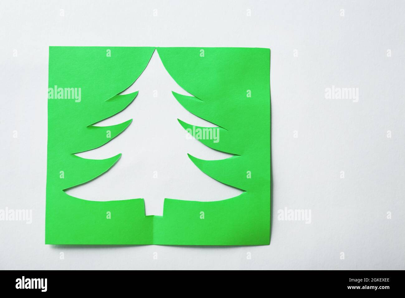 Sheet of paper with cut out Christmas tree on white background Stock ...