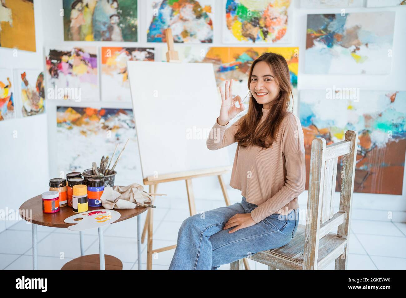 female artist standing next to her painting and showing thumb up Stock ...
