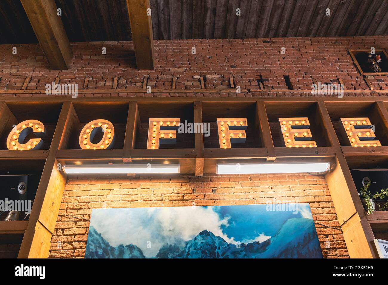 Coffee in illuminated lights on a brick wall at a trendy coffee shop ...