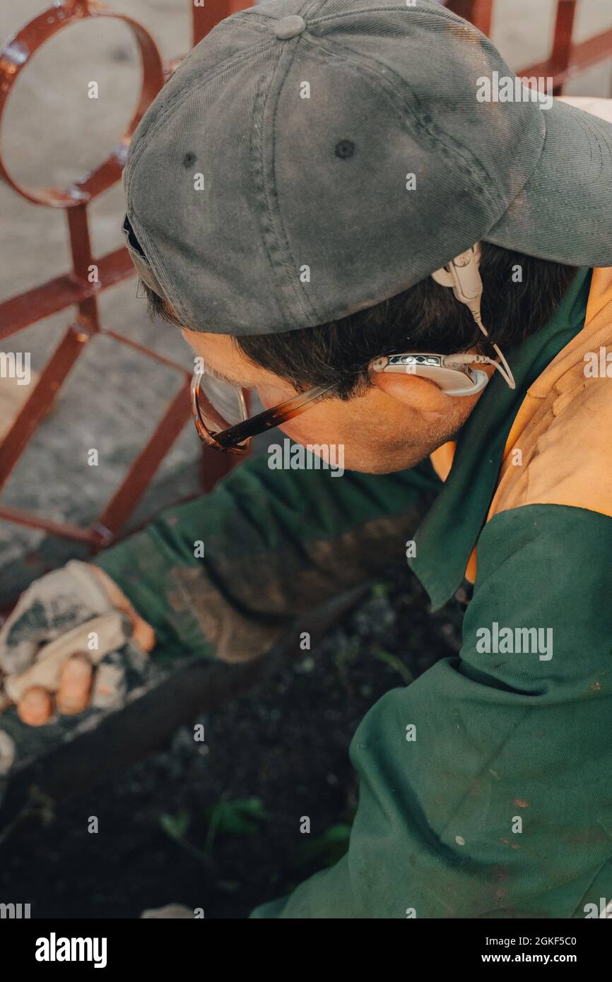 Construction technicians with hearing aid working with cement paving ...
