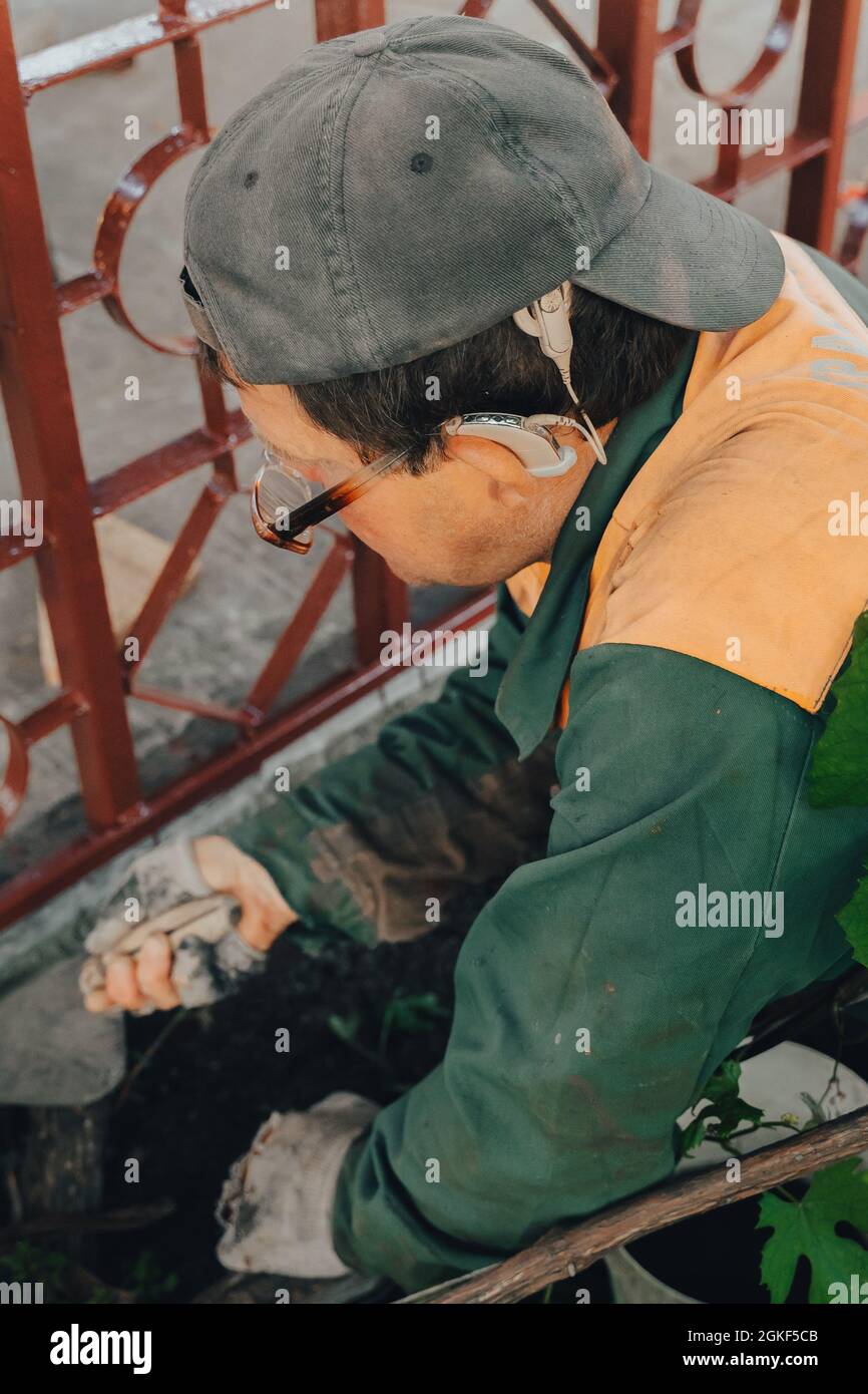 Construction technicians with hearing aid working with cement paving ...
