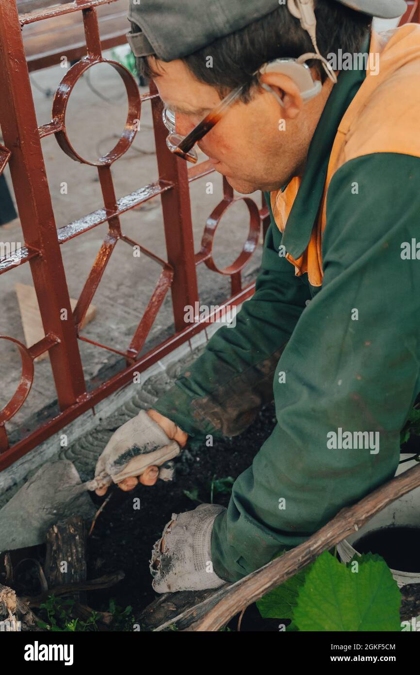 Construction technicians with hearing aid working with cement paving ...