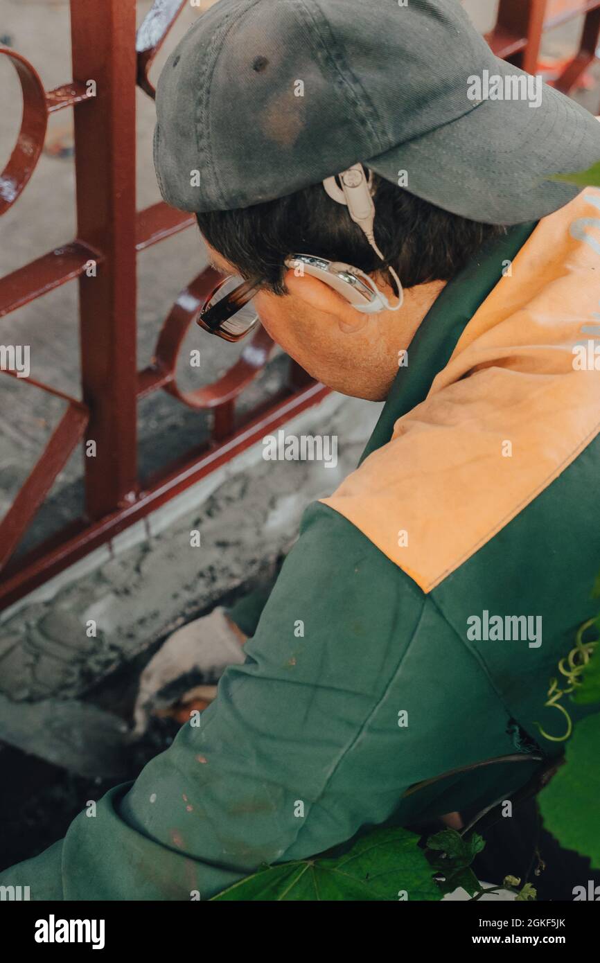 Construction technicians with hearing aid working with cement paving ...