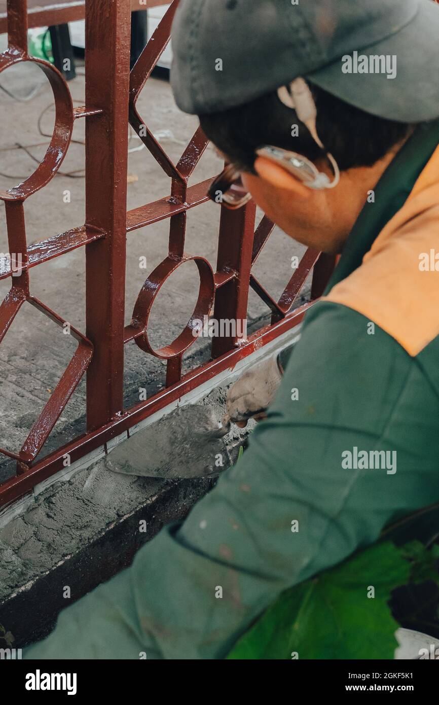 Construction technicians with hearing aid working with cement paving ...