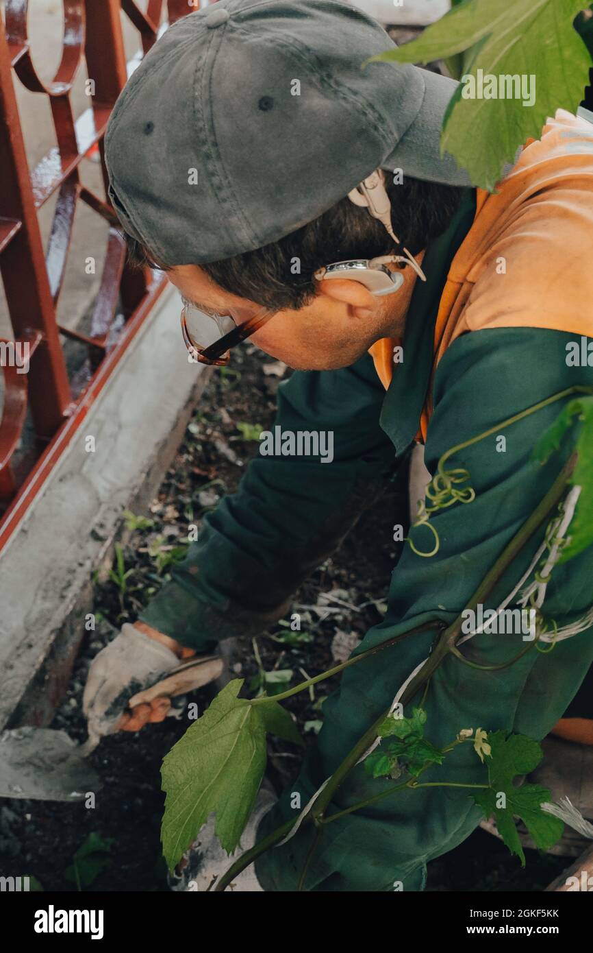 Construction technicians with hearing aid working with cement paving ...