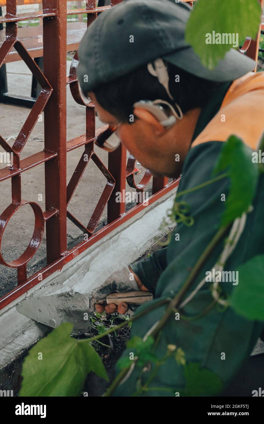 Construction technicians with hearing aid working with cement paving ...