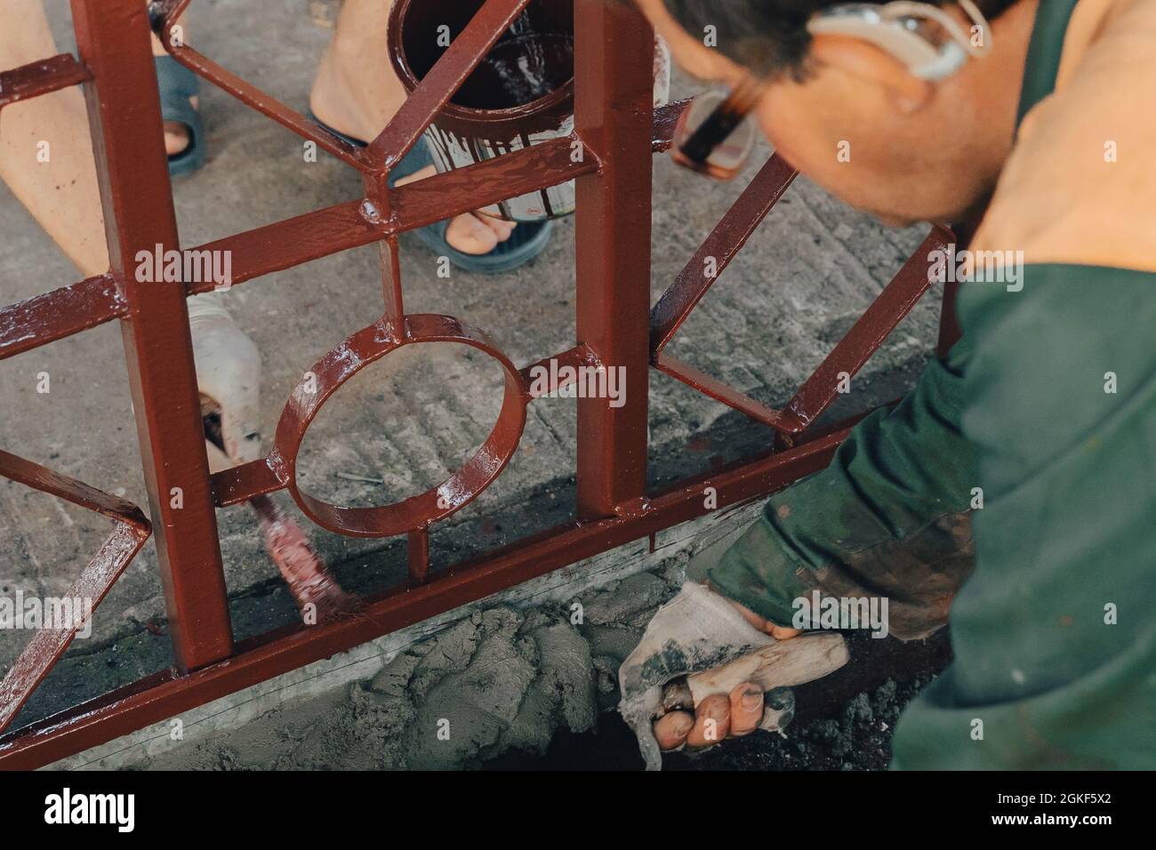 Construction technicians with hearing aid working with cement paving ...